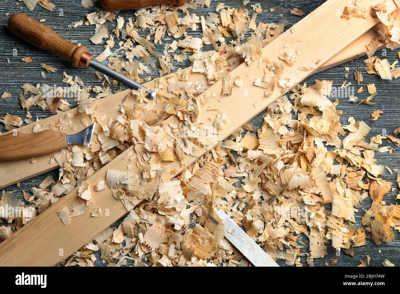 Set of tools, wooden boards and saw dust on table in carpenter's ...