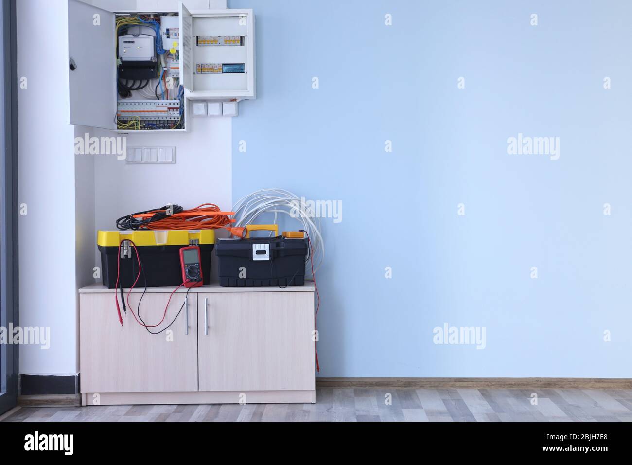 Distribution board with wires and tools on table in light room Stock ...