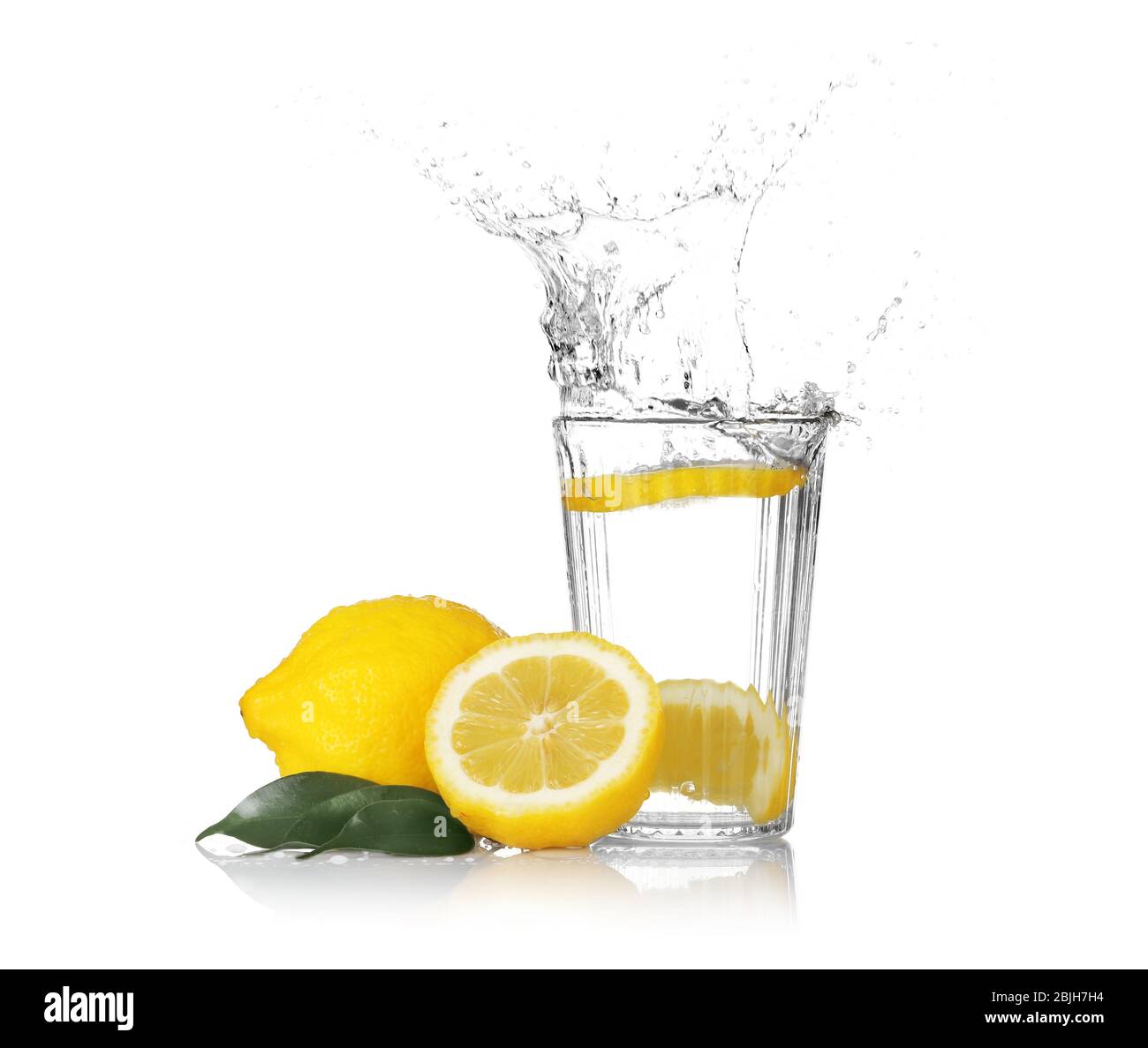 Fresh slice of lemon falling into glass with water on white background Stock Photo - Alamy