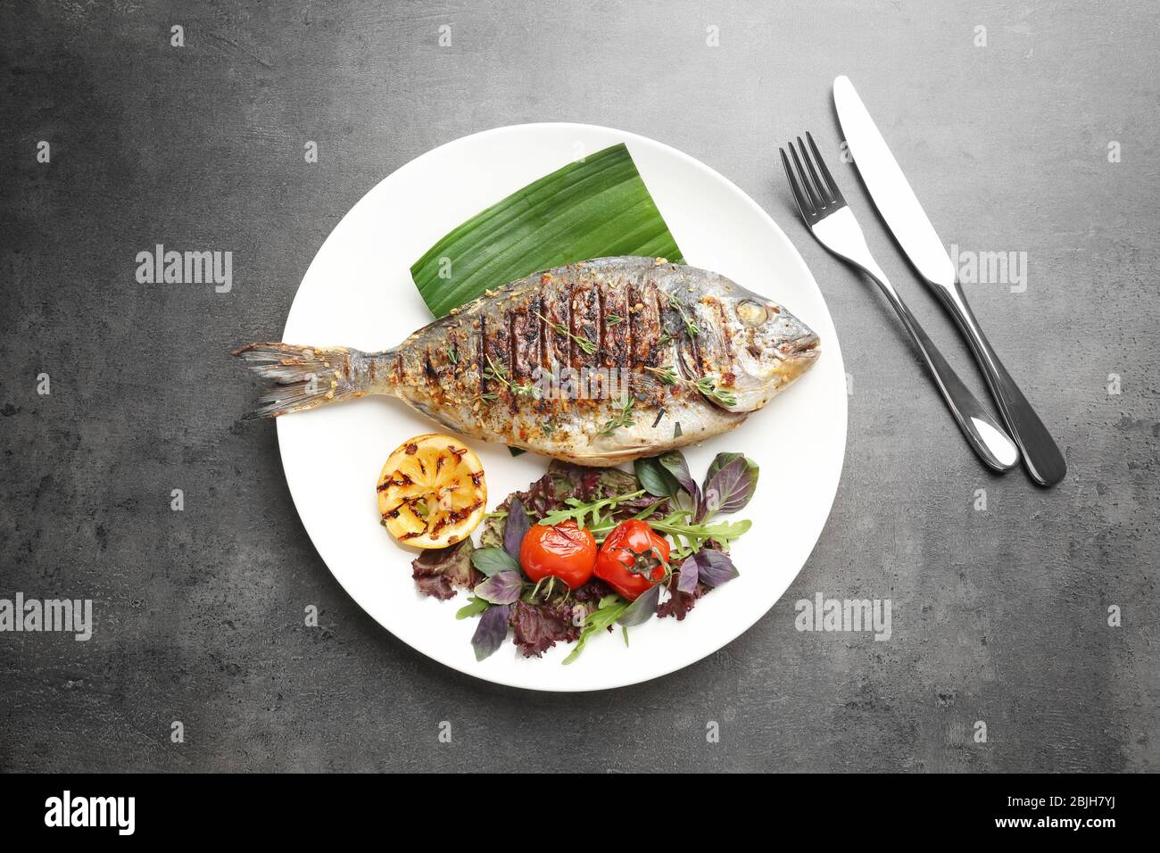 Plate with delicious fried fish on table Stock Photo - Alamy