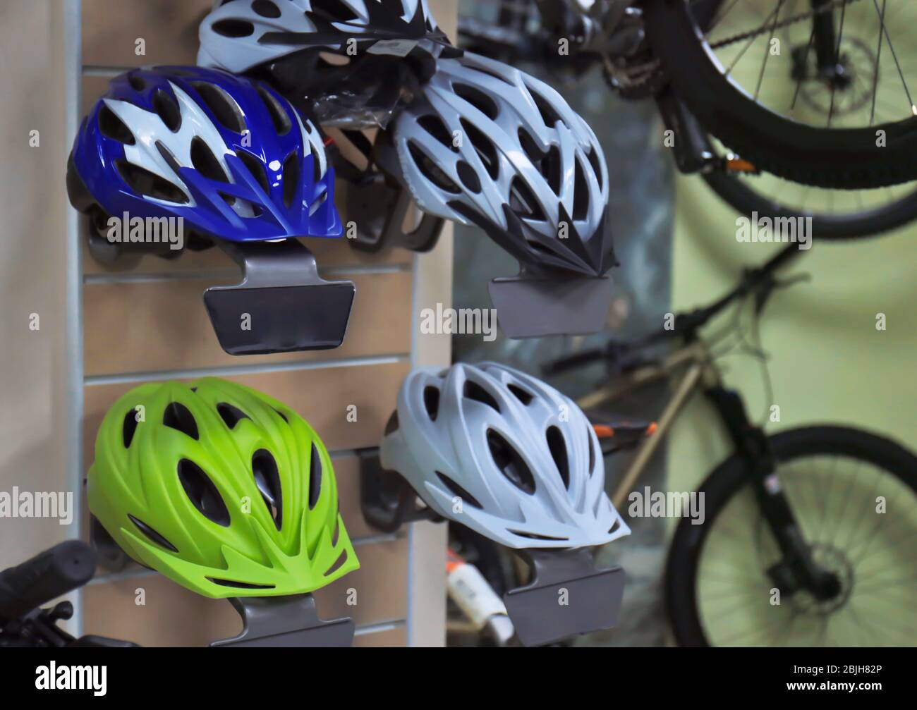 Stand with helmets in bicycle shop Stock Photo - Alamy
