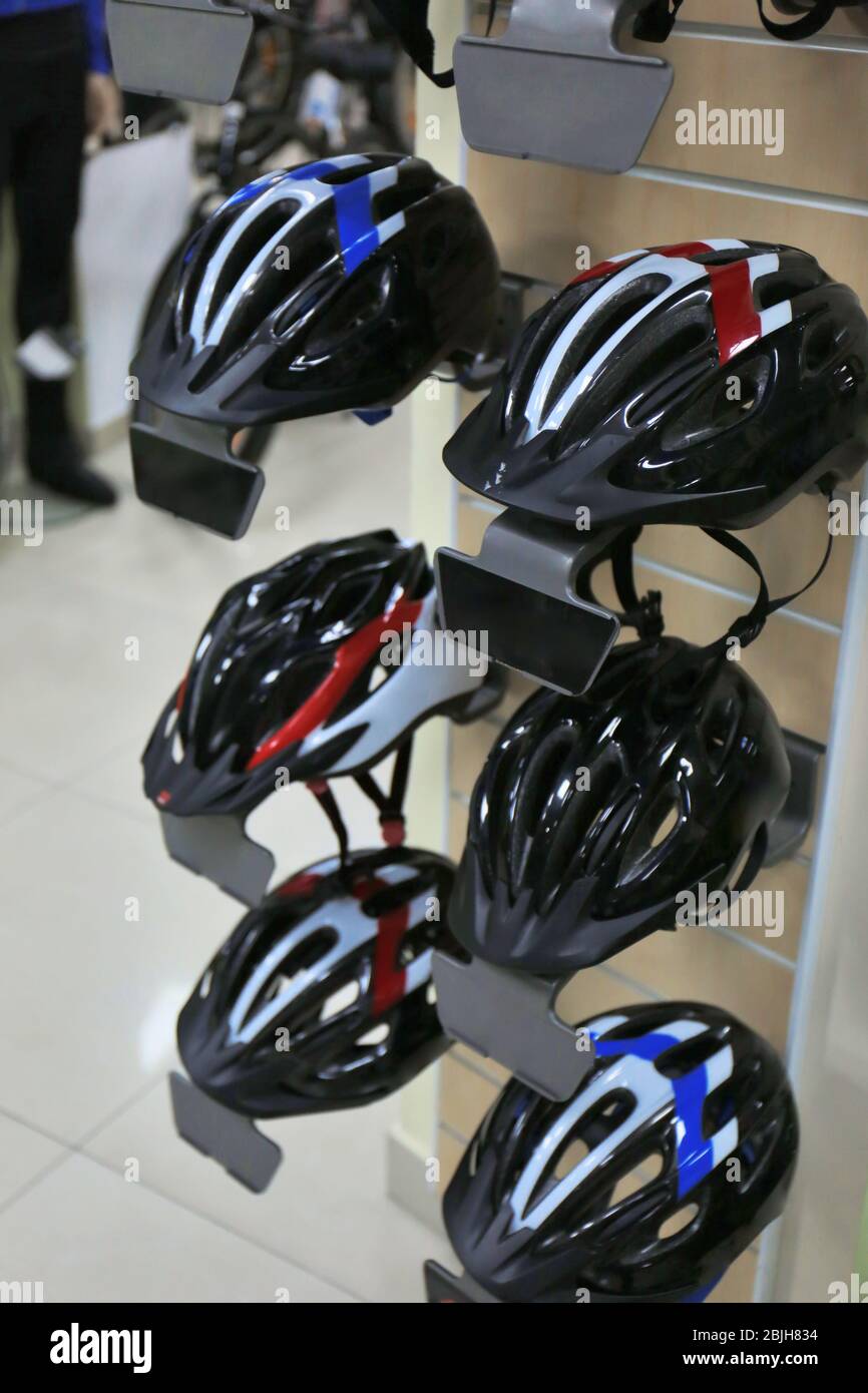 Stand with helmets in bicycle shop Stock Photo - Alamy