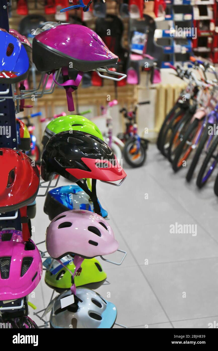 Stand with helmets in bicycle shop Stock Photo - Alamy