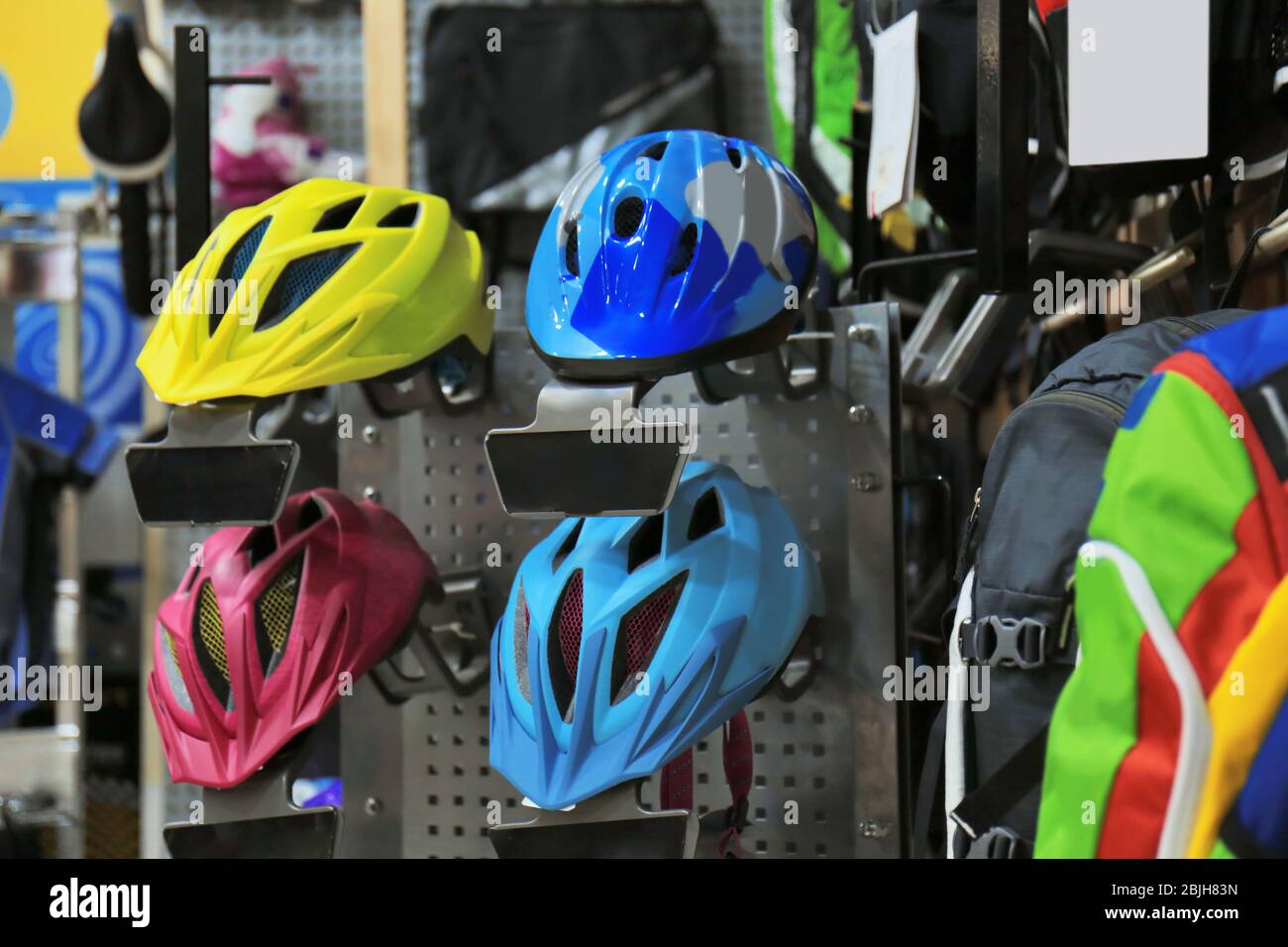 Stand with helmets in bicycle shop Stock Photo - Alamy