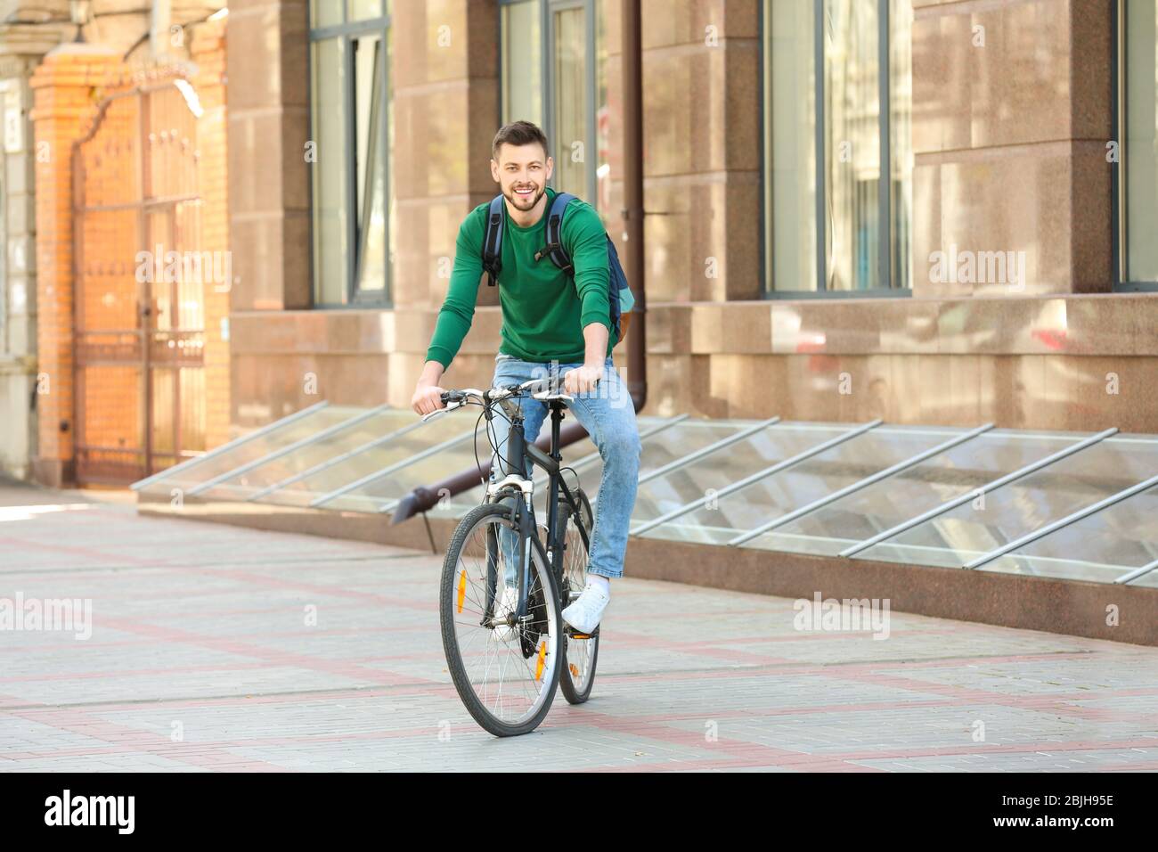 Handsome young man riding bicycle outdoors Stock Photo - Alamy