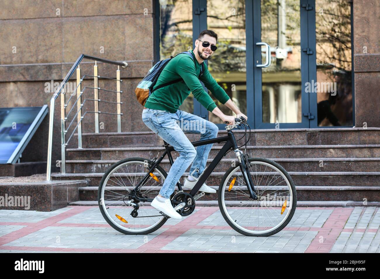 Handsome young man riding bicycle outdoors Stock Photo - Alamy