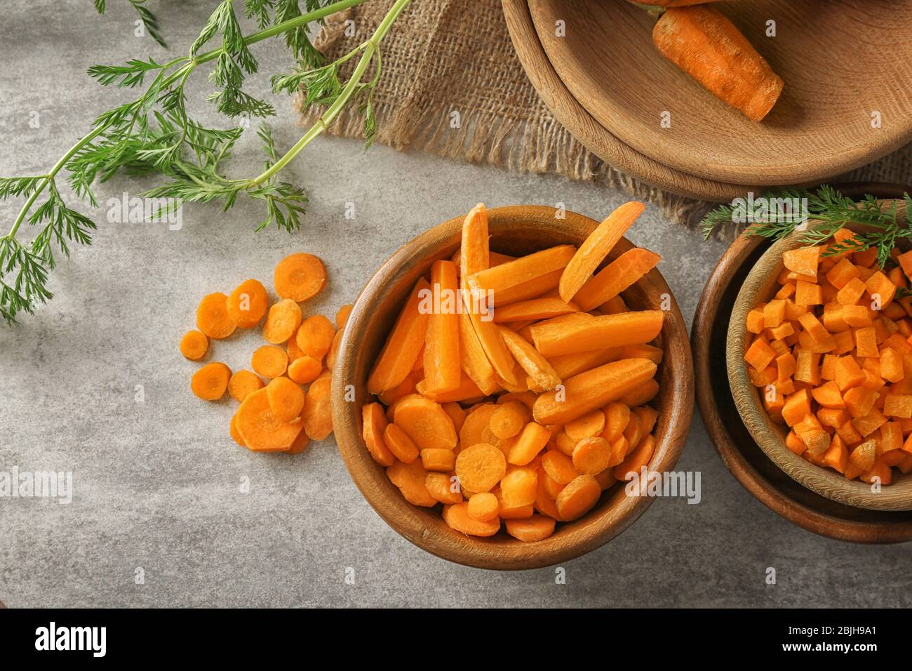 Different cuts of carrot in bowls on grey background Stock Photo - Alamy