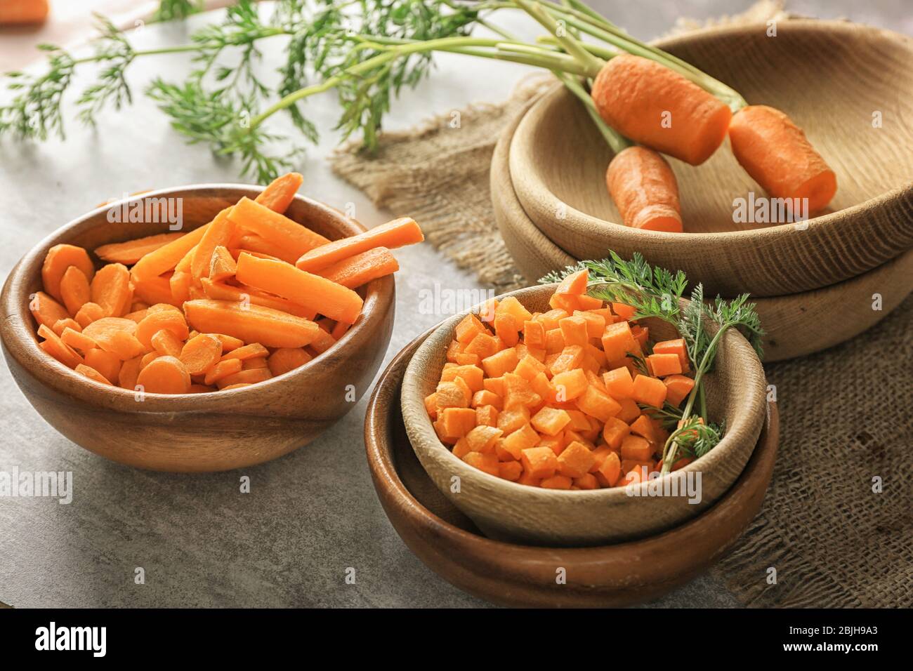 Different cuts of carrot in bowls on grey background Stock Photo - Alamy