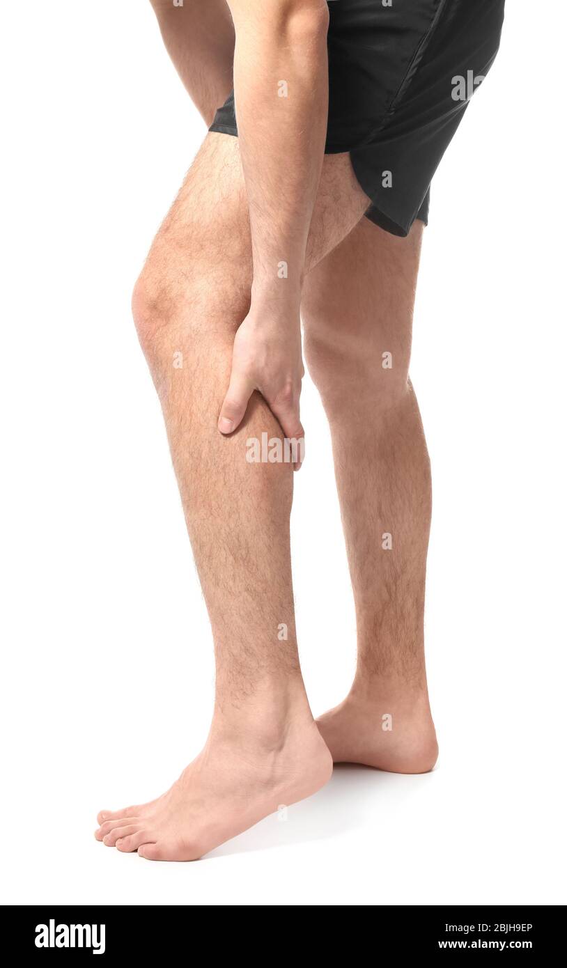 Young man suffering from pain in leg on white background Stock Photo ...