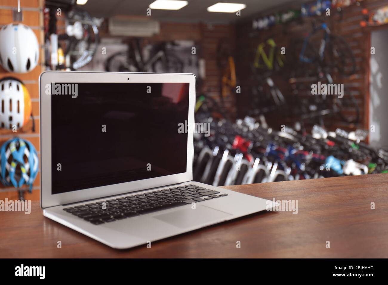 Counter with modern laptop in bicycle shop Stock Photo - Alamy