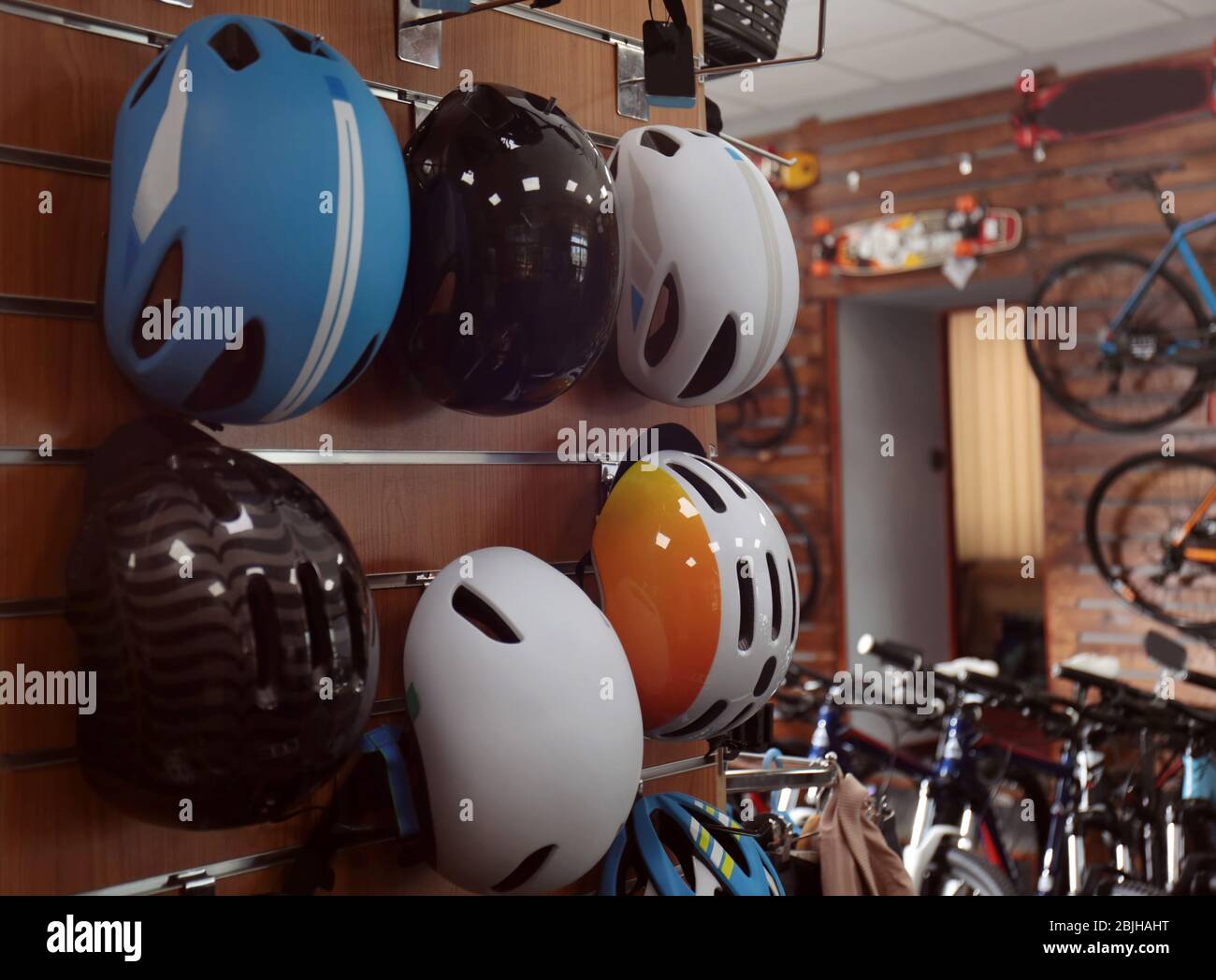 Stand with helmets in bicycle shop Stock Photo - Alamy