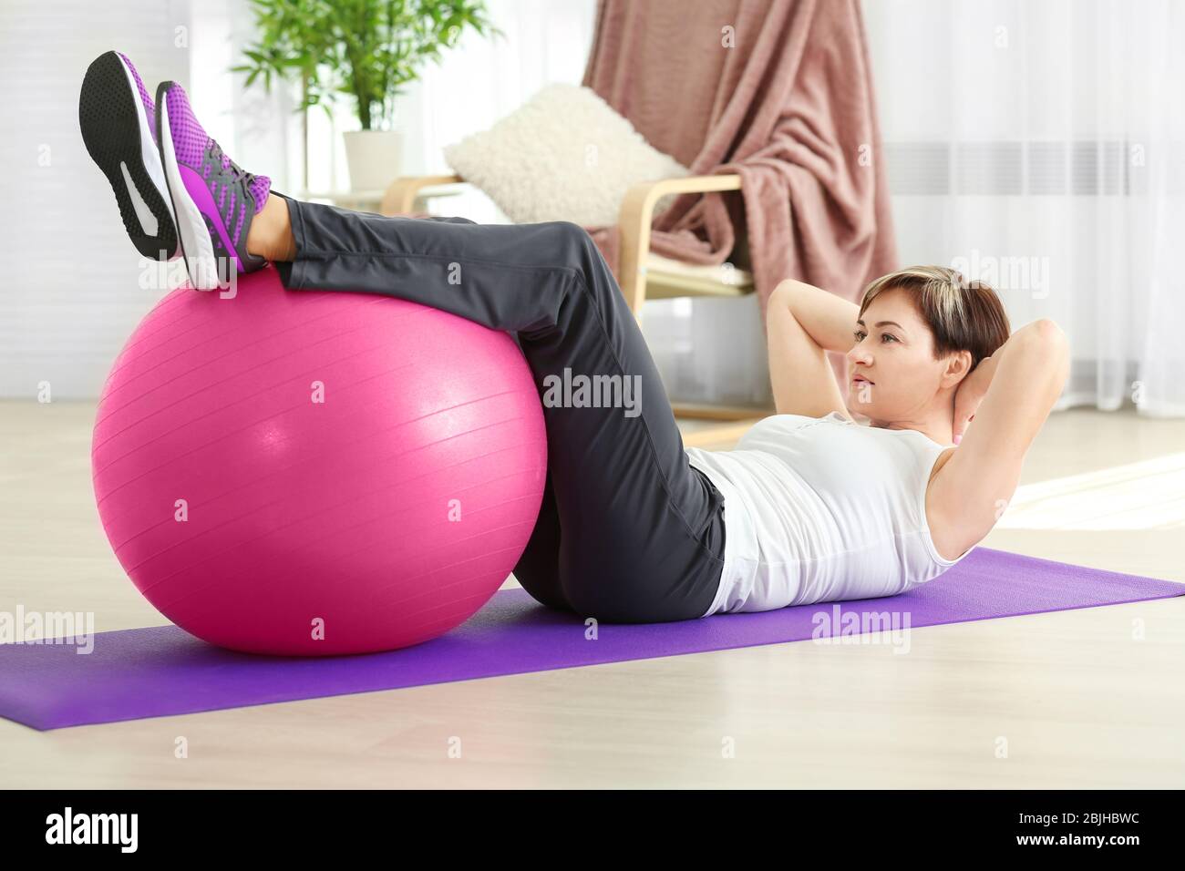 Mature woman training with fitball at home. Weight loss concept Stock ...