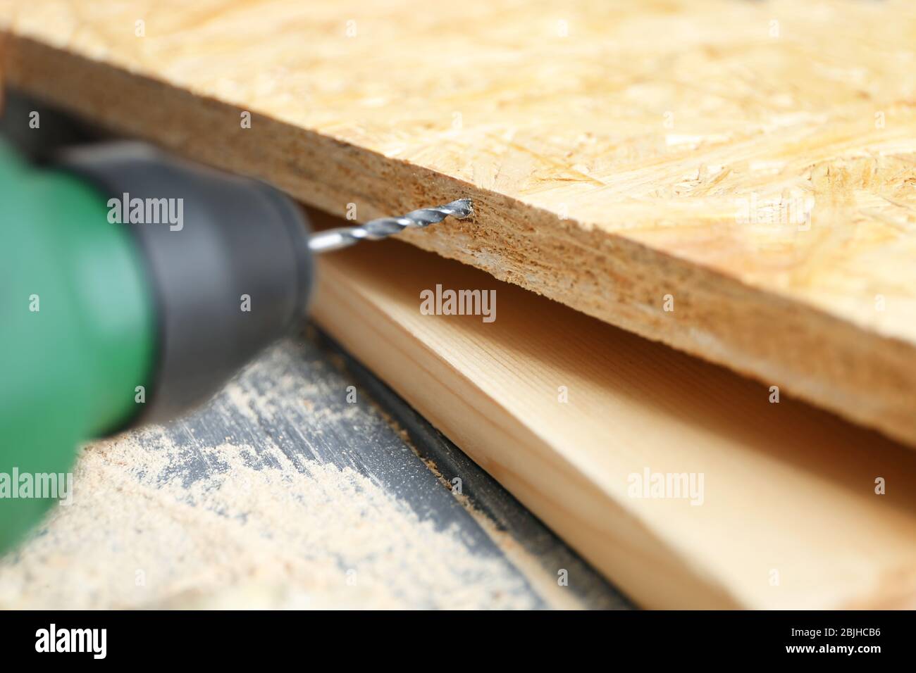 Drilling hole in wooden board at carpenter's workshop, closeup Stock ...
