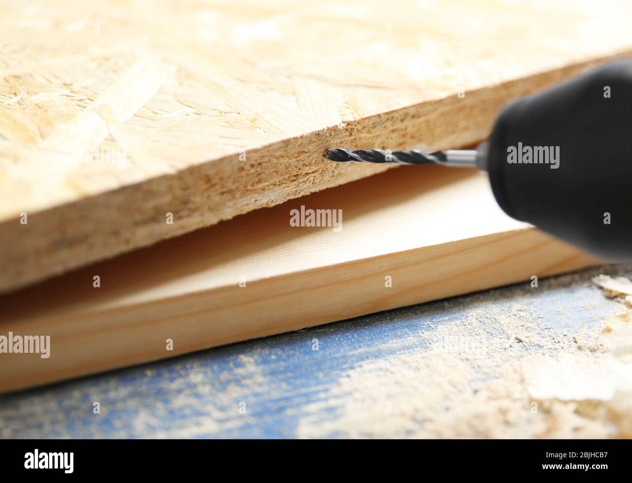 Drilling hole in wooden board at carpenter's workshop, closeup Stock ...