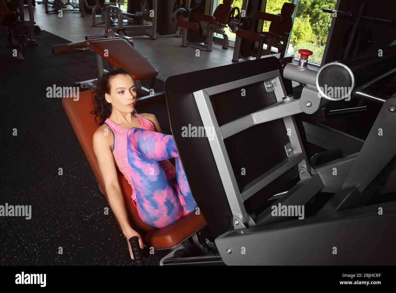Sporty young woman training legs in gym Stock Photo - Alamy