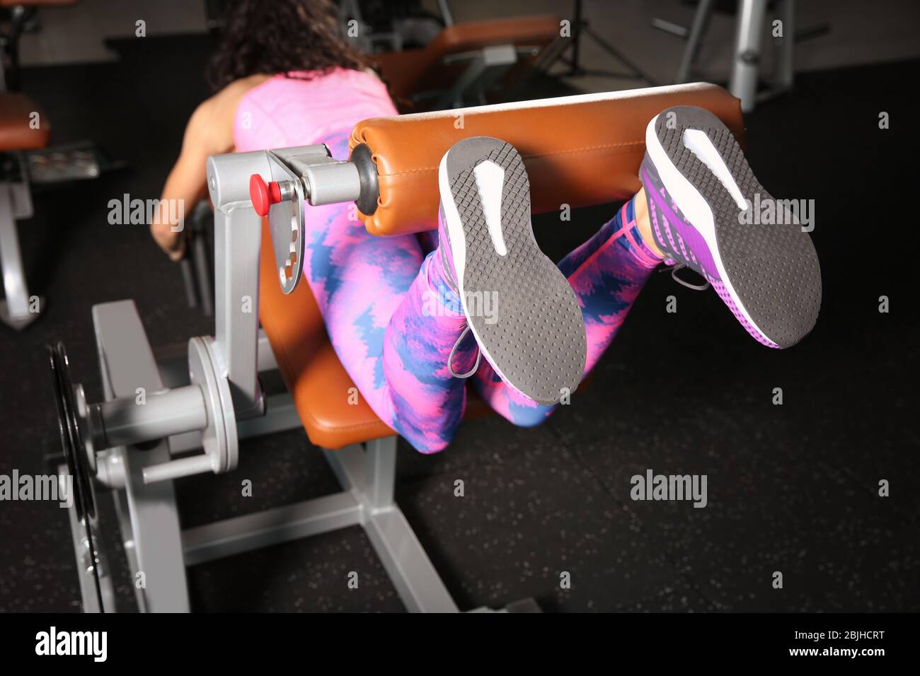 Sporty young woman training legs in gym Stock Photo - Alamy