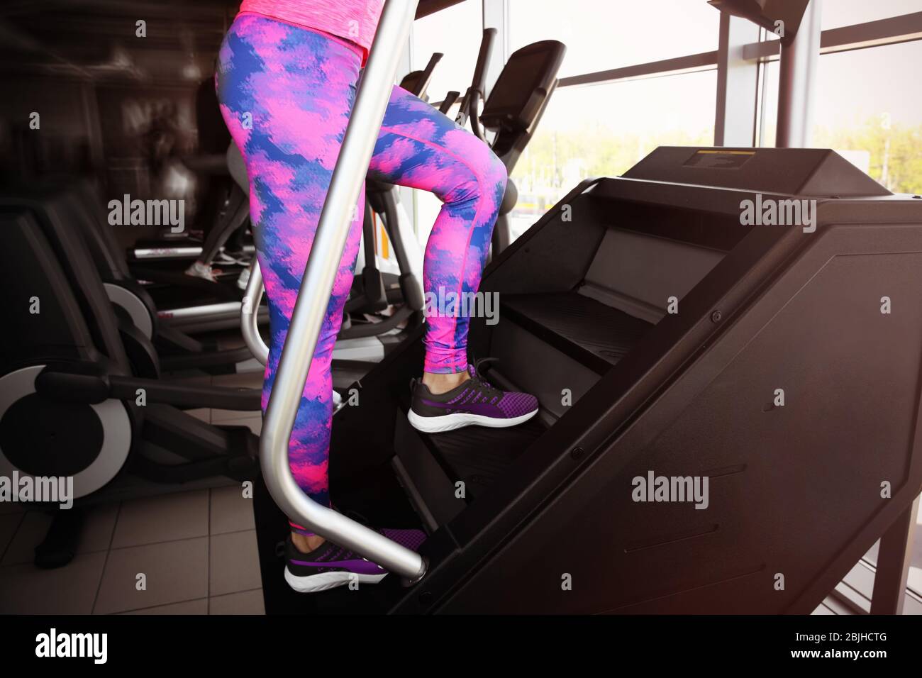 Sporty young woman training legs in gym Stock Photo - Alamy