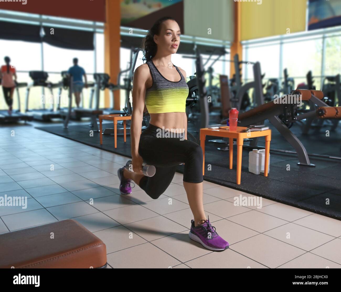 Sporty young woman training legs in gym Stock Photo - Alamy