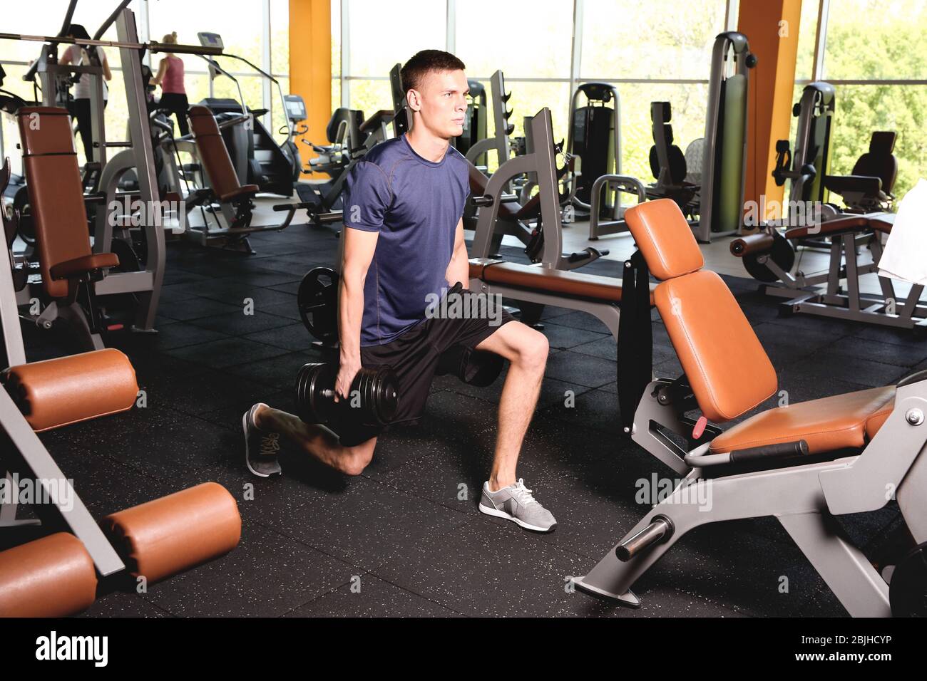 Sporty young man training legs in gym Stock Photo - Alamy