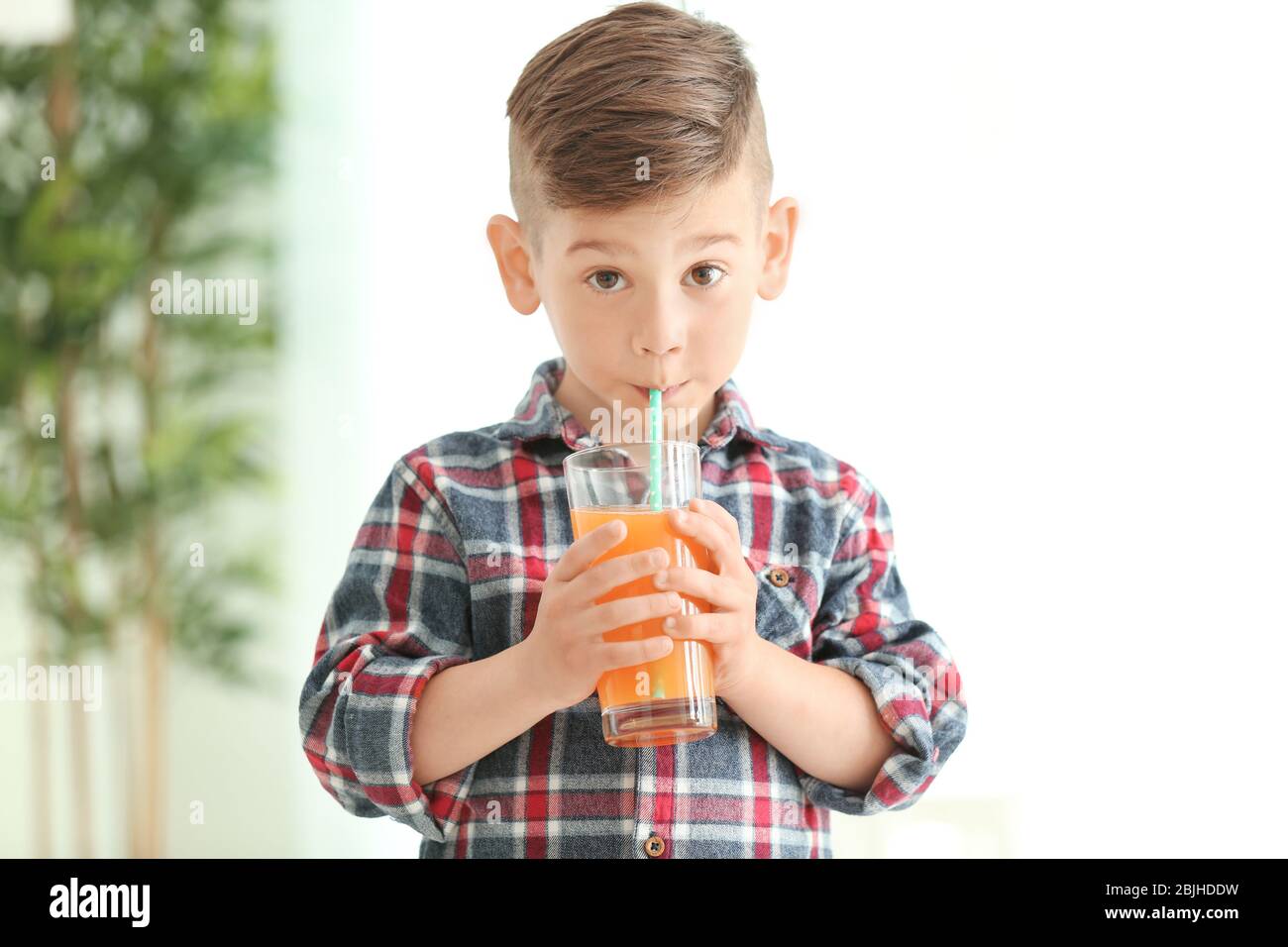 Cute little boy drinking juice at home Stock Photo - Alamy