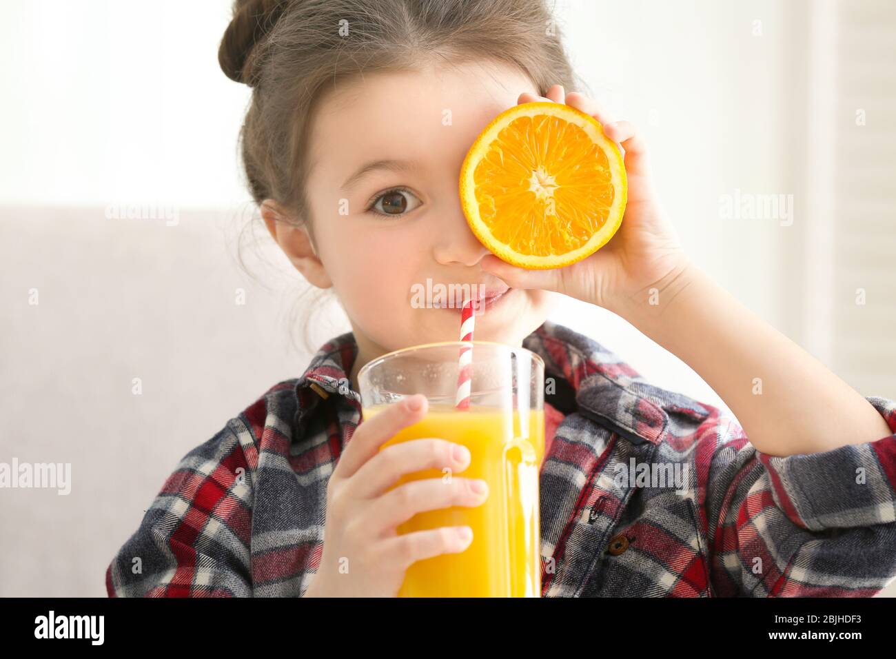 Cute little girl drinking juice at home, closeup Stock Photo - Alamy