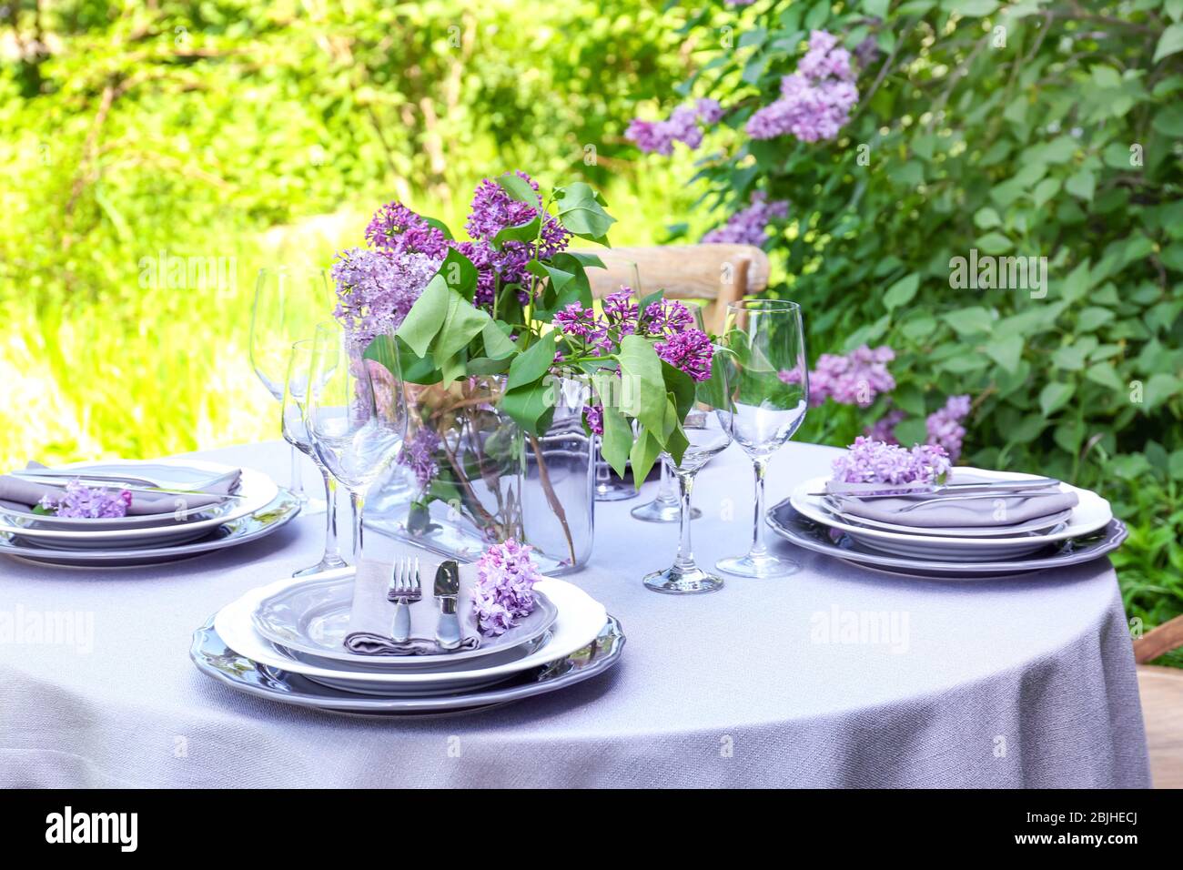 Table setting for dinner in beautiful lilac garden Stock Photo - Alamy