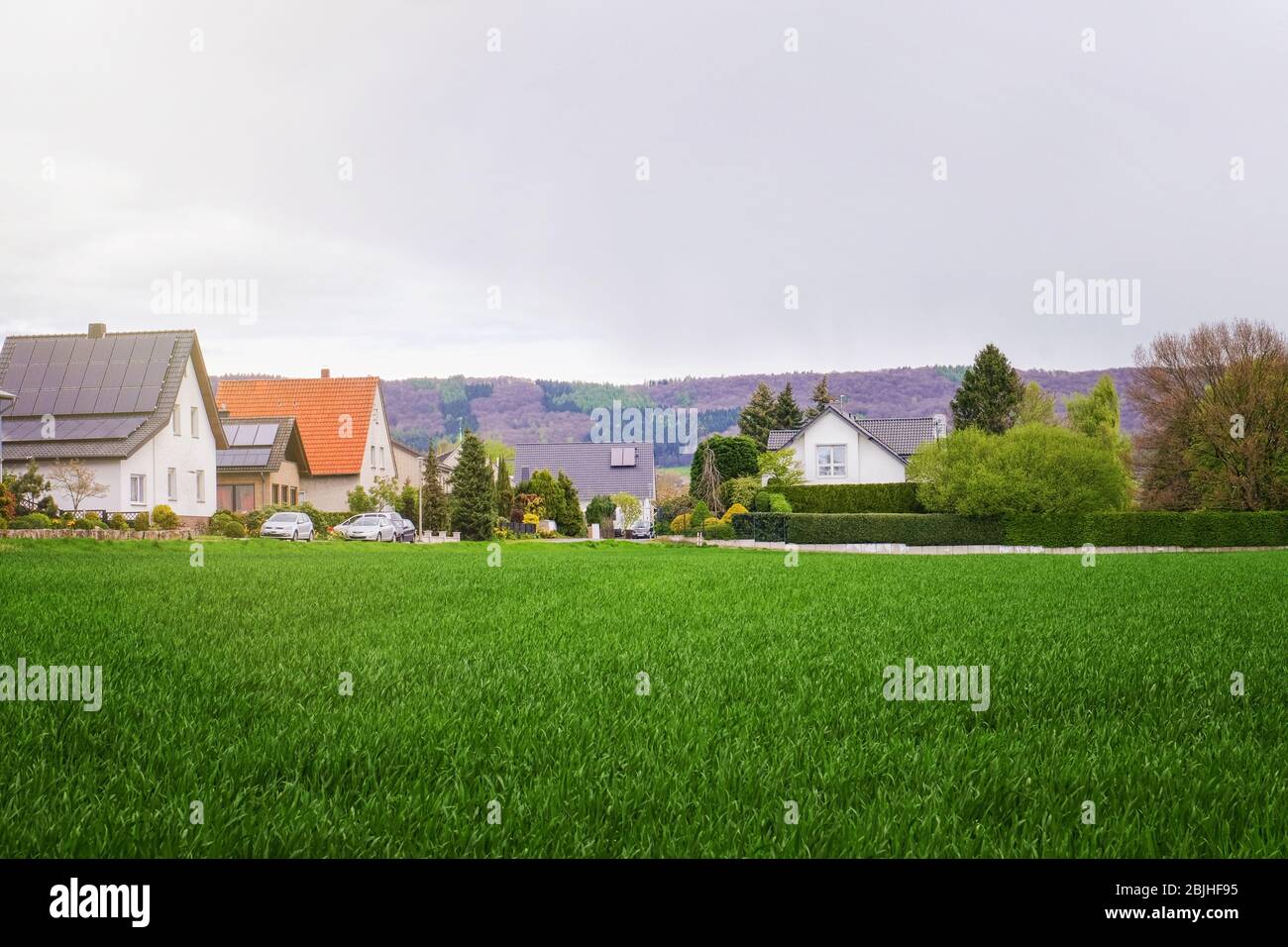 Beautiful countryside landscape with green field and houses Stock Photo ...