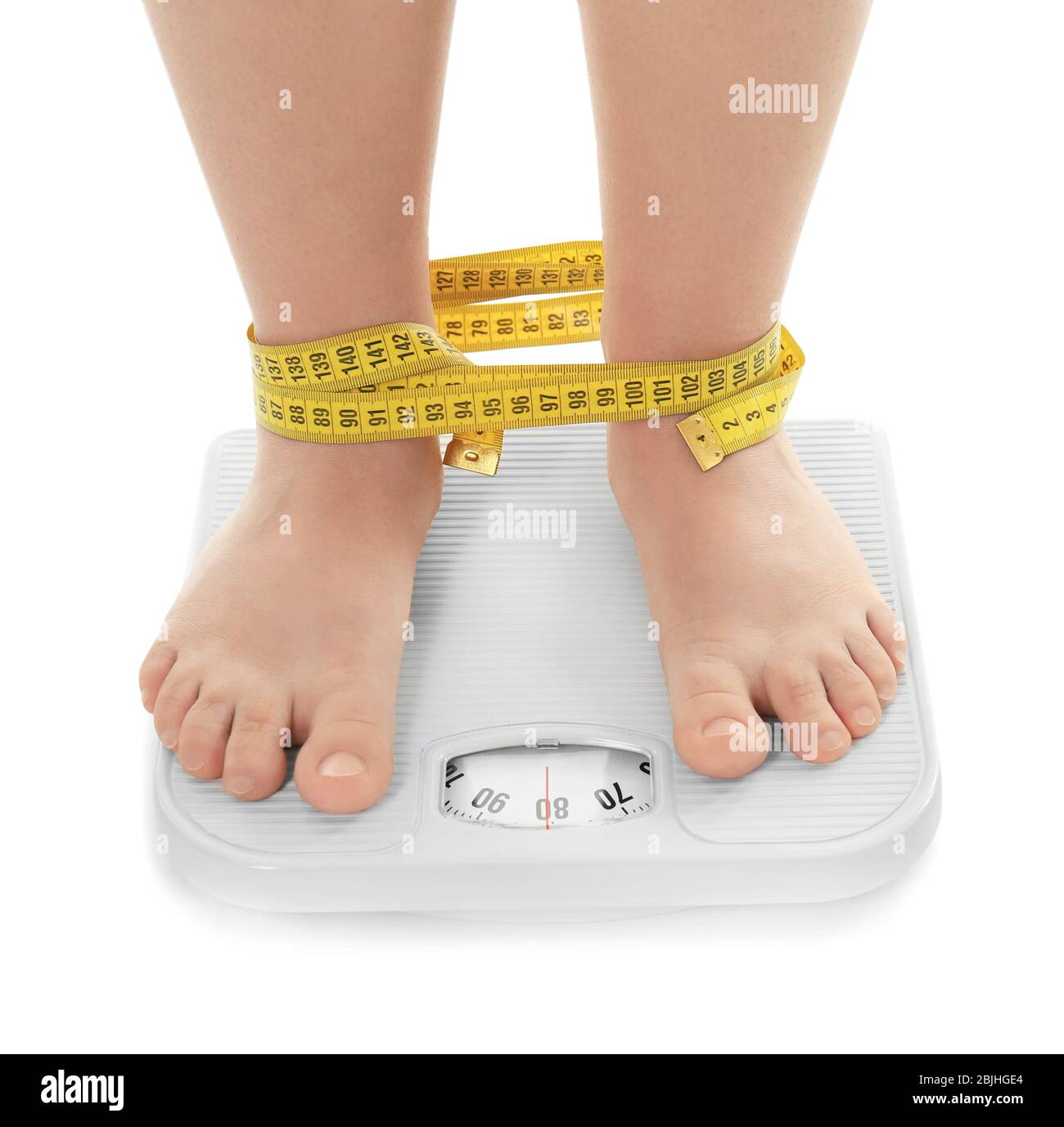 Overweight woman measuring her weight using scales, on white background ...