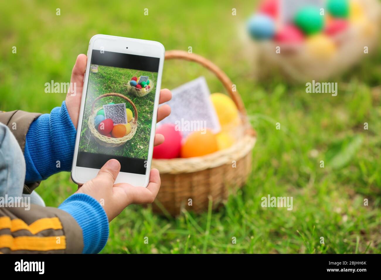 Little boy scanning QR Code in basket with colorful eggs at park ...