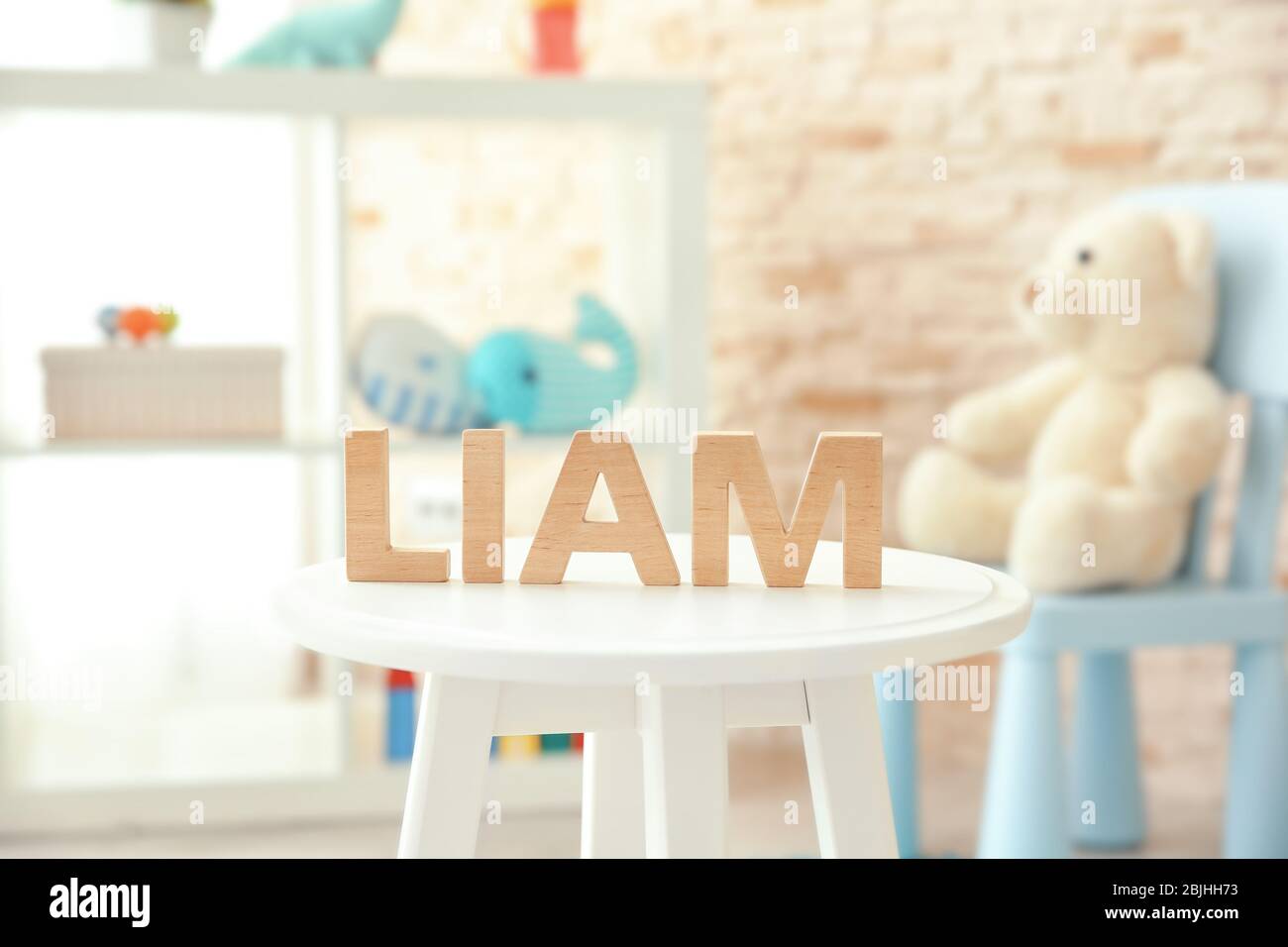Baby name LIAM composed of wooden letters on table. Choosing name ...