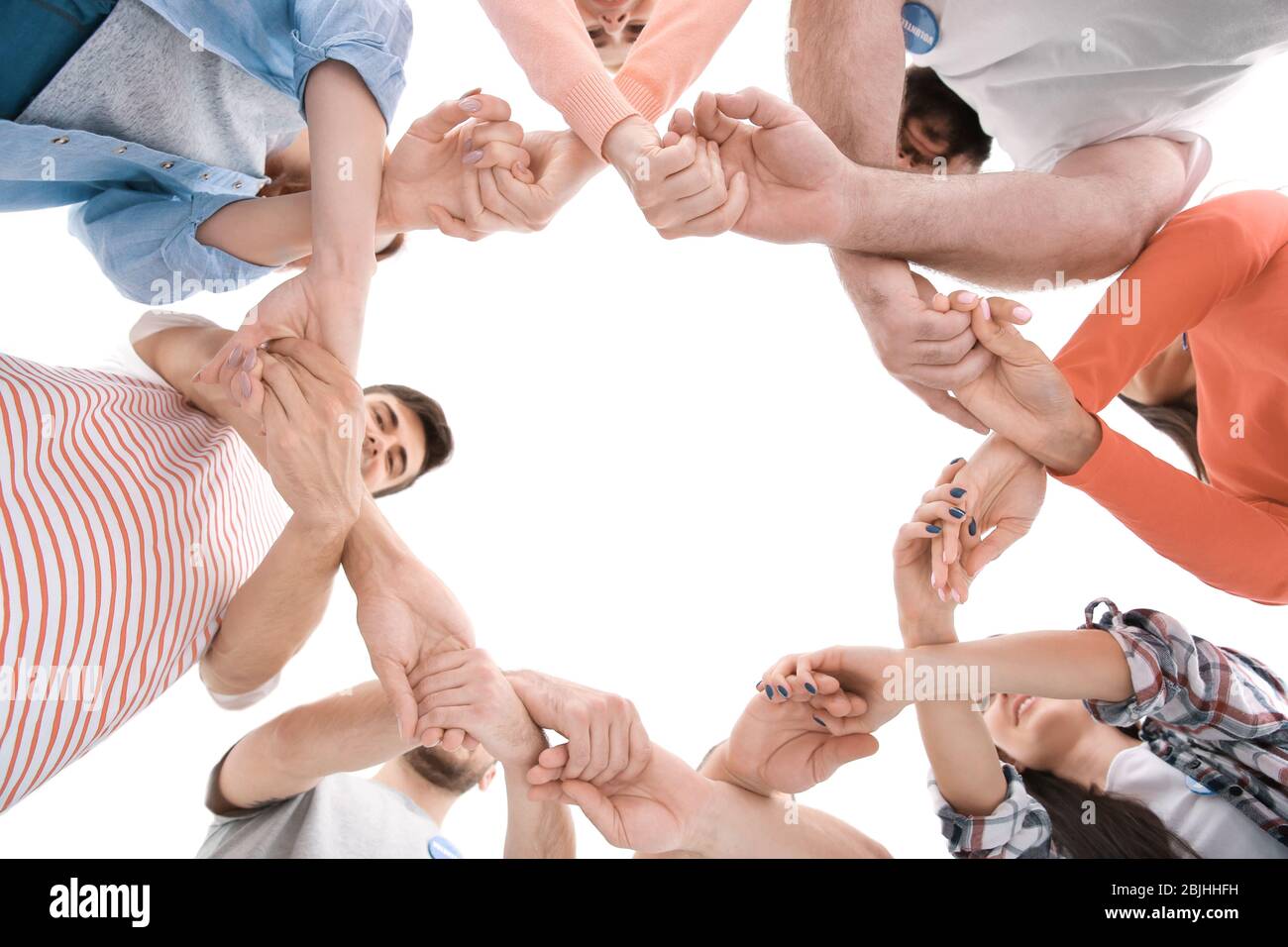 Group of young volunteers making circle with their hands on white ...