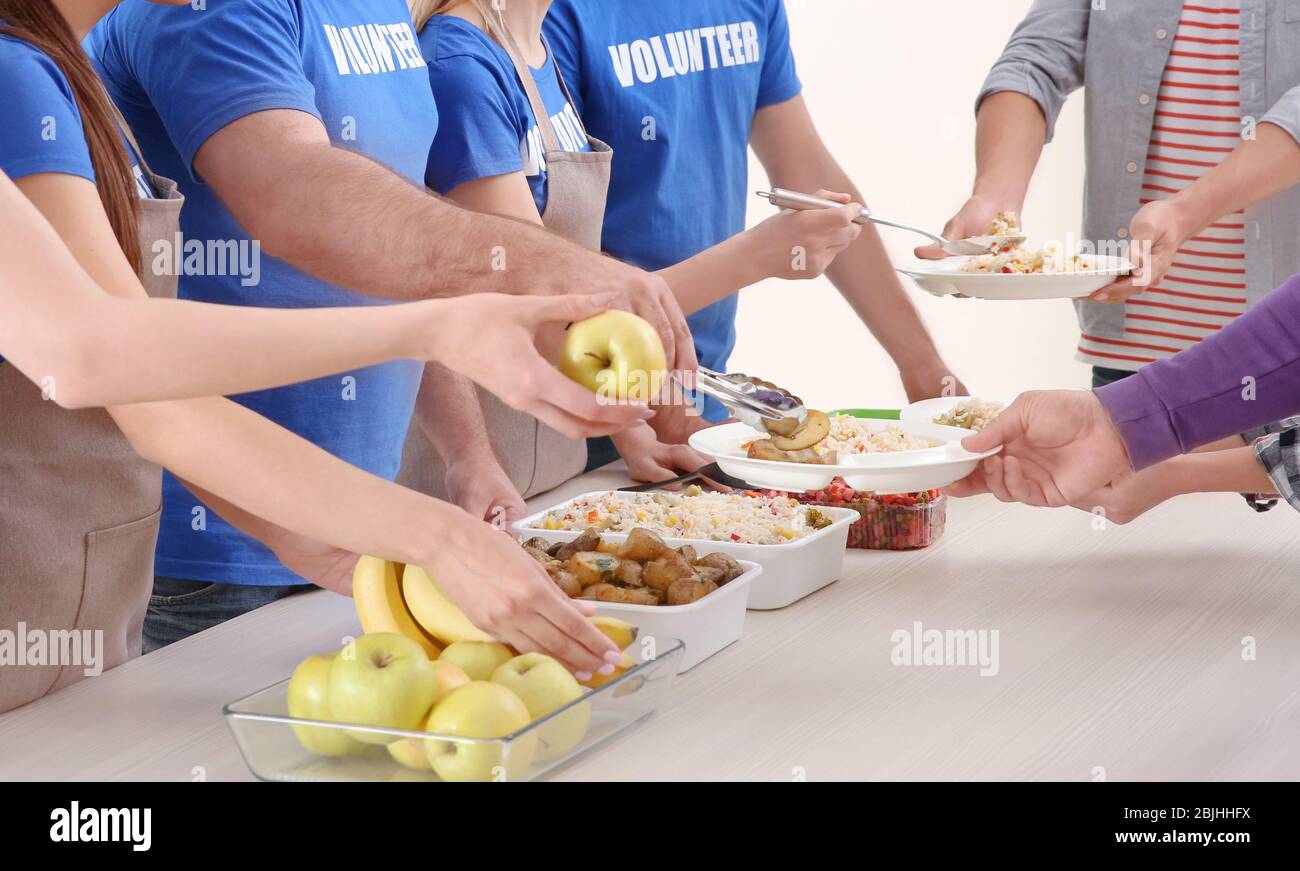 Young volunteers serving food to homeless people Stock Photo - Alamy