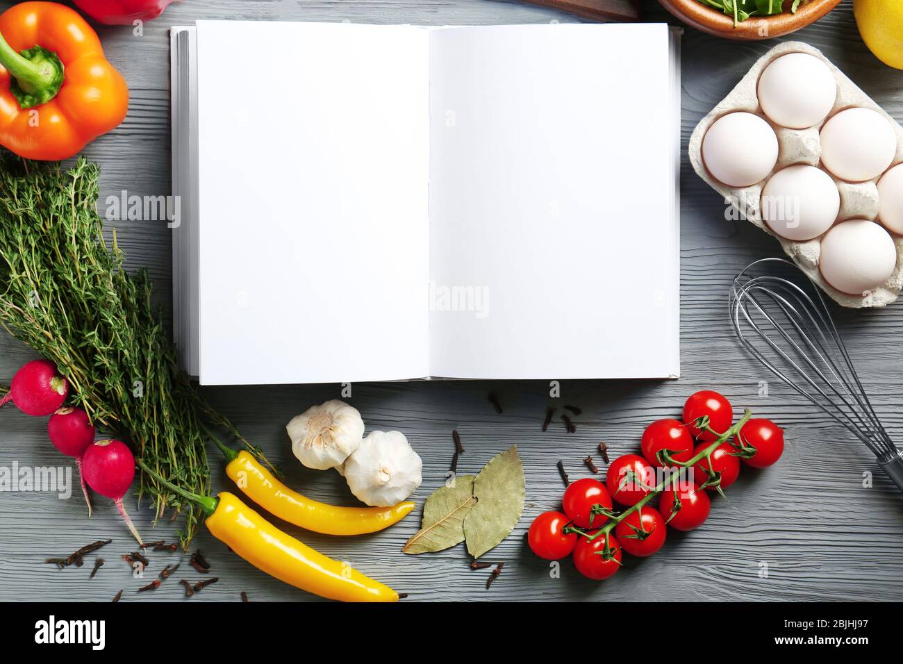 Open notebook and vegetables on kitchen table. Cooking classes concept ...