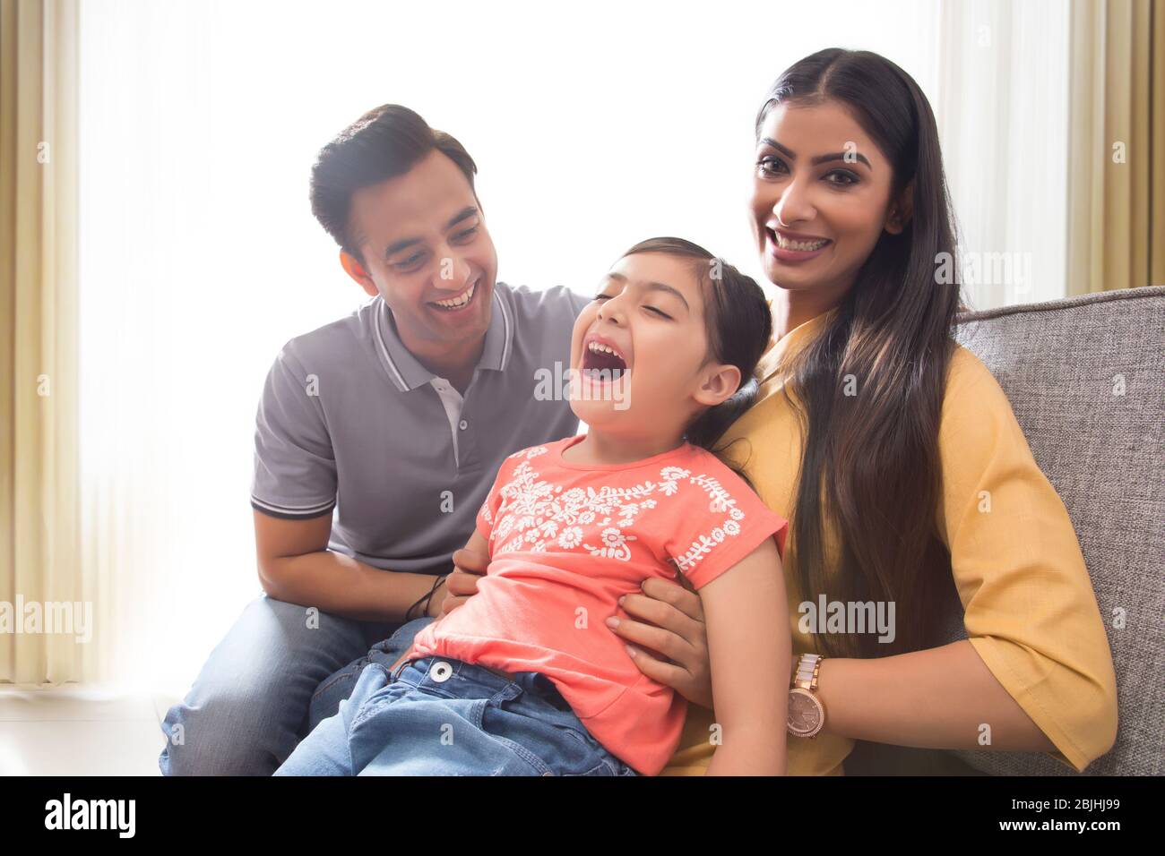 Happy family having fun together on sofa Stock Photo - Alamy