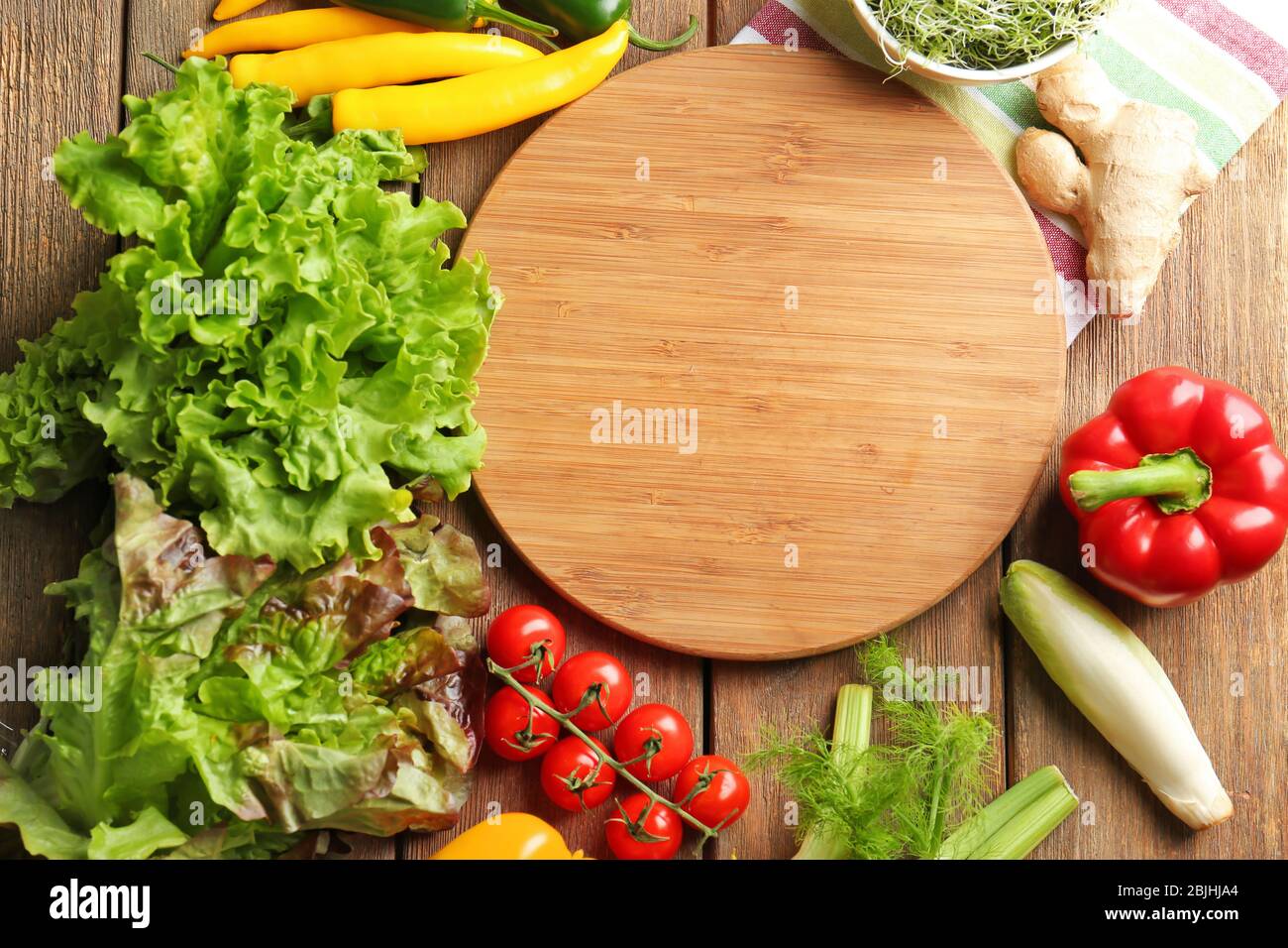 Wooden board and vegetables on kitchen table. Cooking classes concept ...