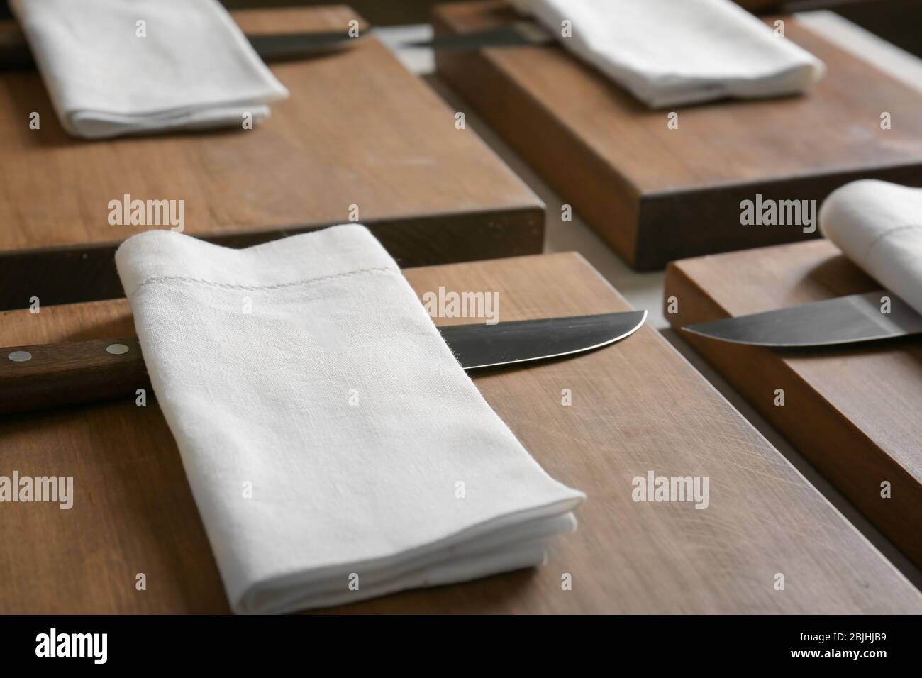Knives with napkins and wooden boards on kitchen table. Cooking classes ...