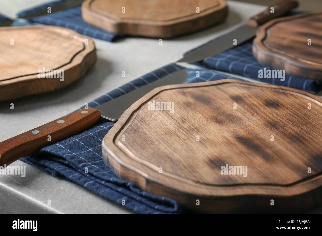 Knives and napkins with wooden boards on kitchen table. Cooking classes ...