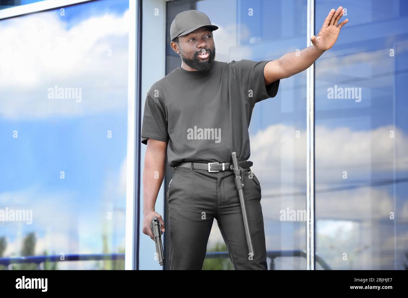 Male security guard showing stop gesture near big modern building Stock ...