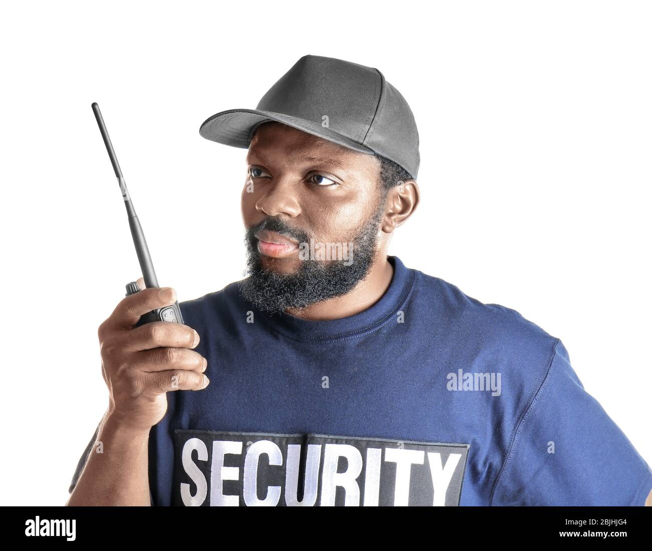 Male security guard using portable radio transmitter on white ...