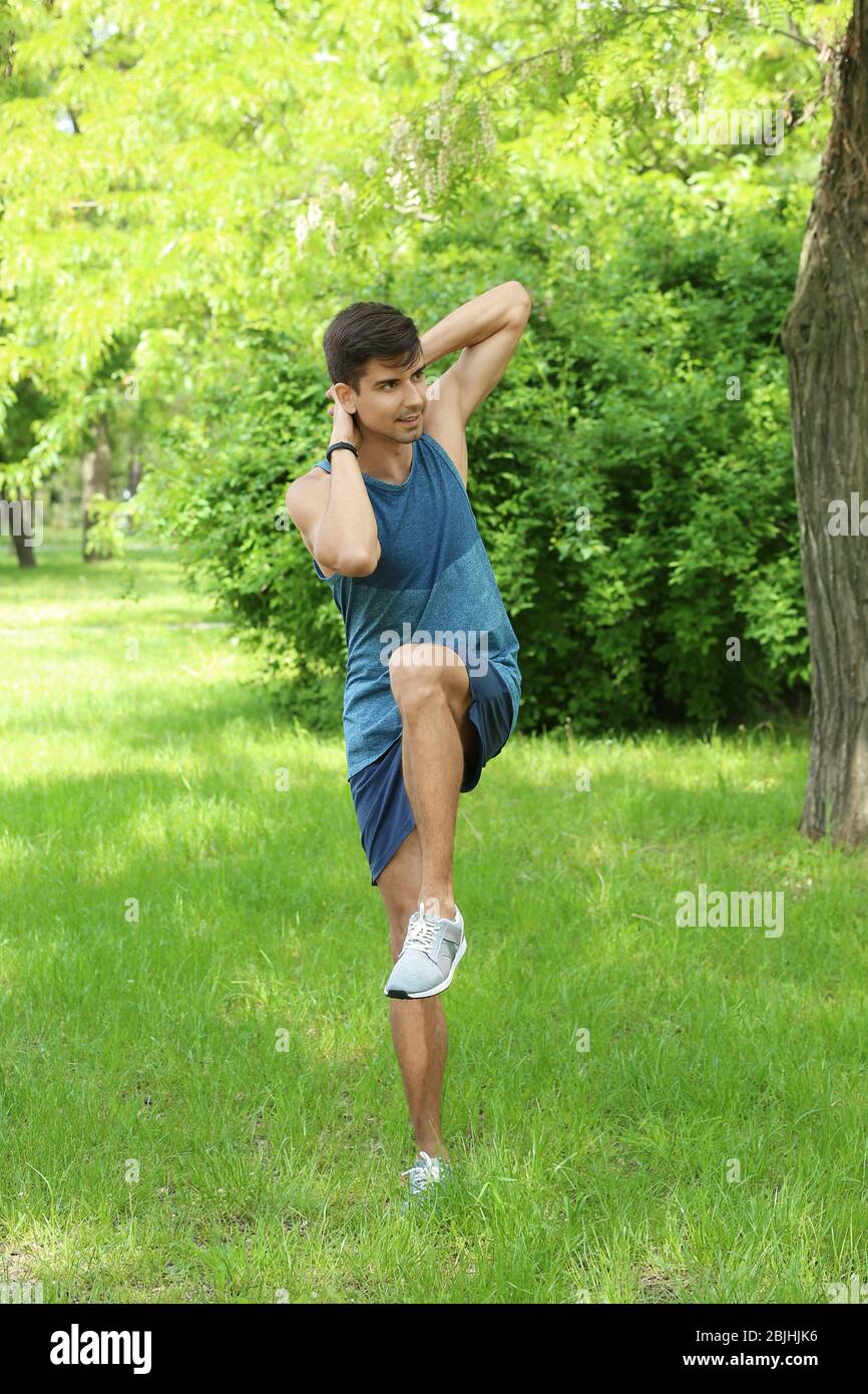 Athletic young man doing bicycle crunch exercise while standing on ...