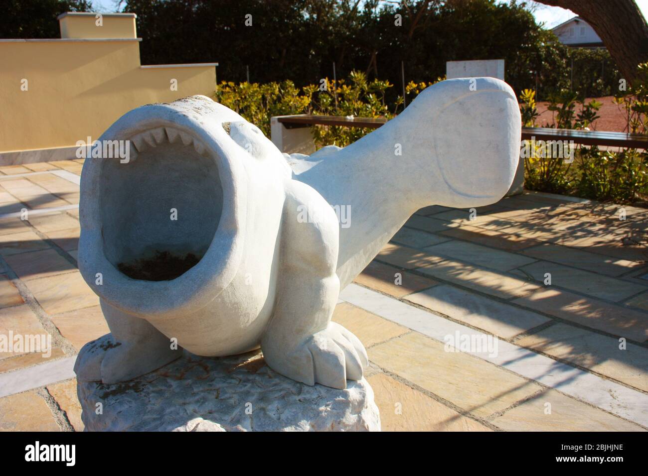 strange statue in white marble depicting a fat fish with a big mouth ...