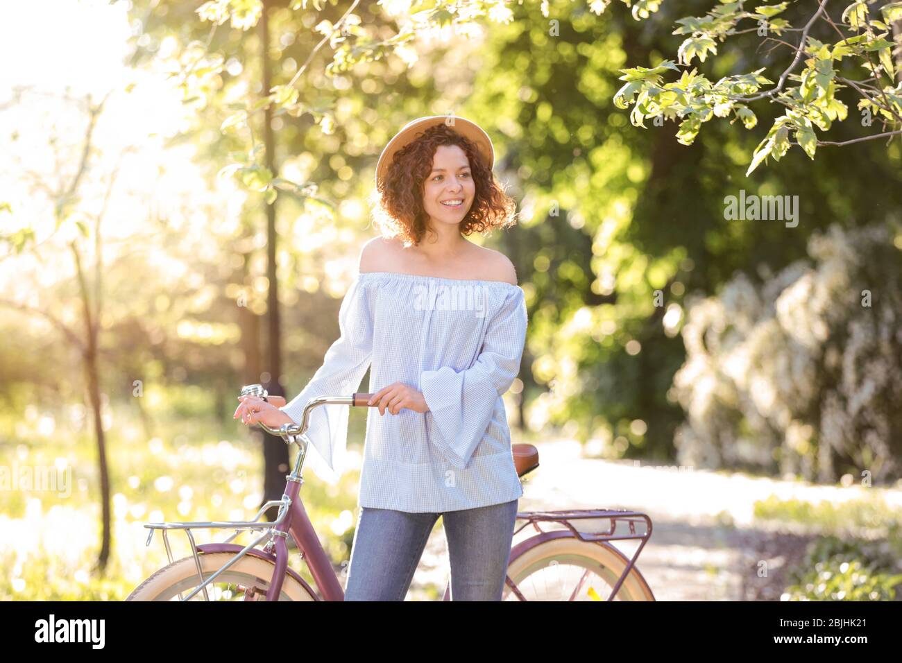 Beautiful young woman with bicycle, outdoors Stock Photo - Alamy