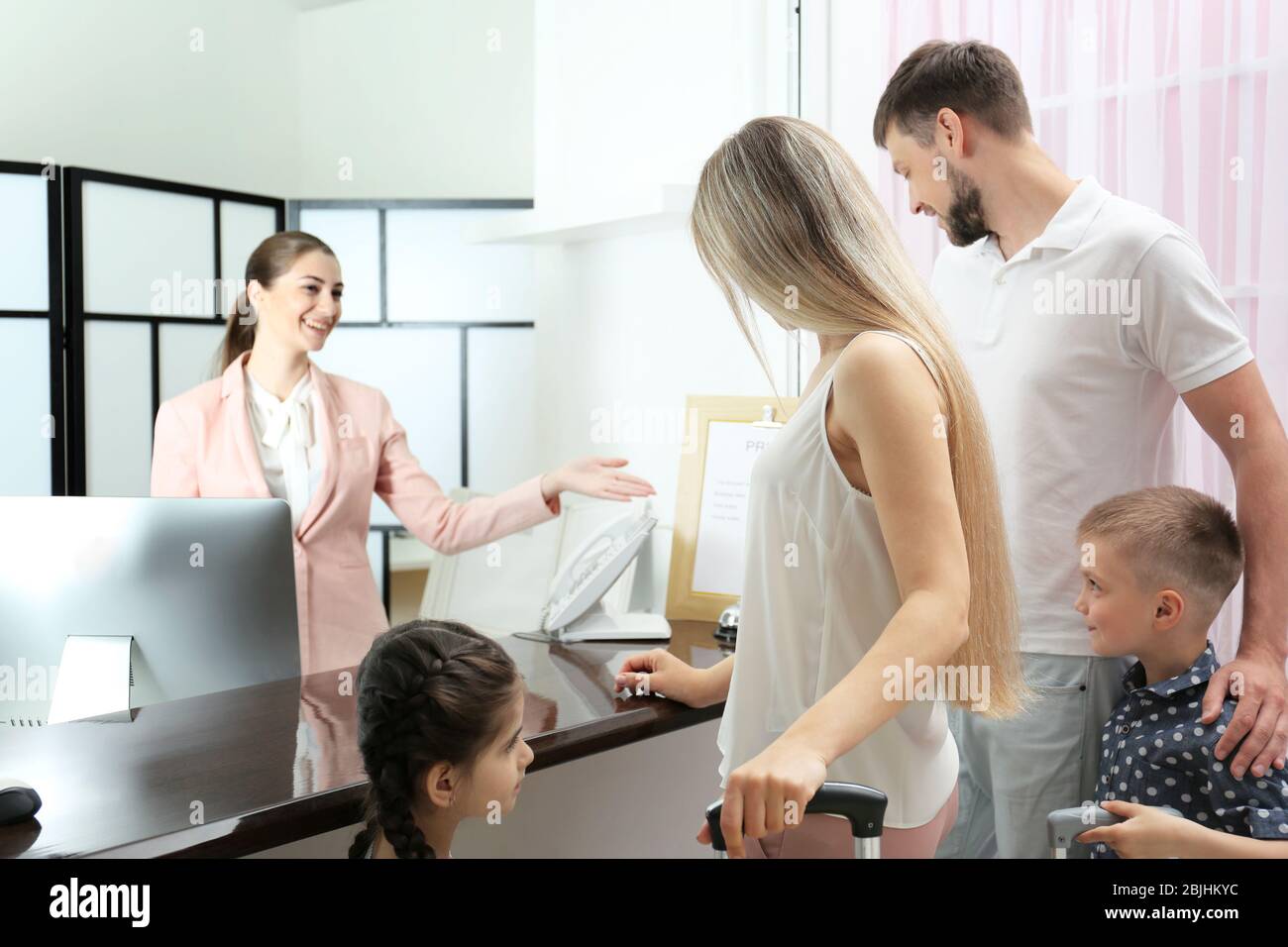 Family on reception at hotel Stock Photo - Alamy