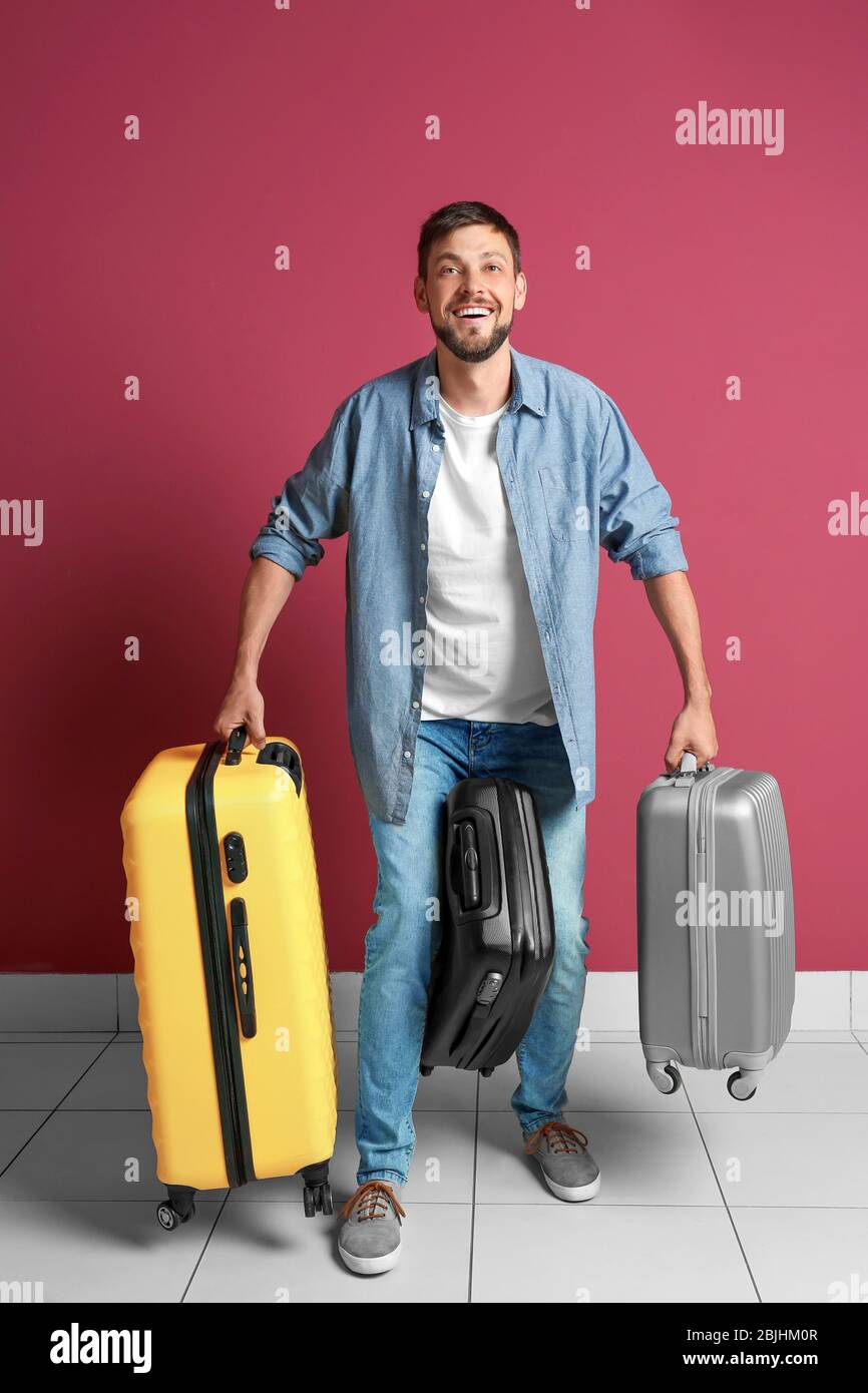 Man with overweight luggage on colorful wall background Stock Photo - Alamy