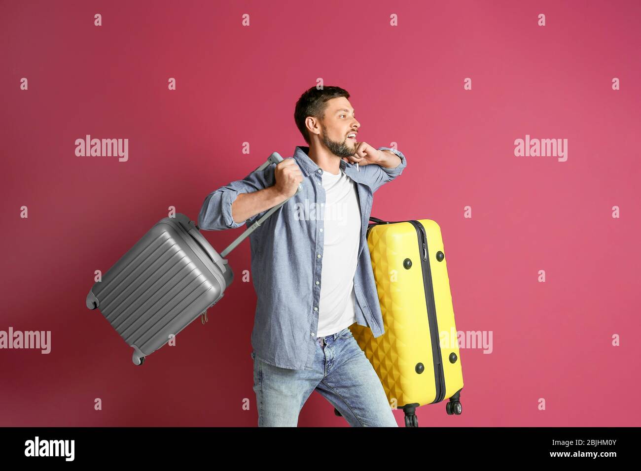 Man with overweight luggage on colorful background Stock Photo - Alamy