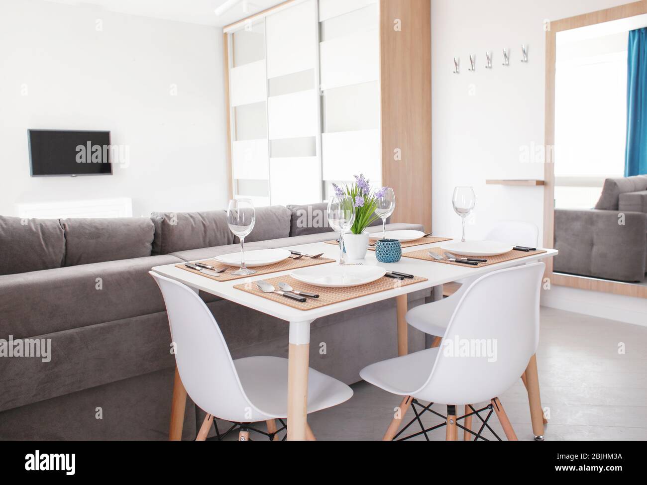 Interior of light modern dining room with served table Stock Photo - Alamy