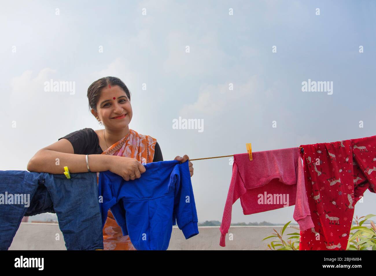 indian woman drying clothes on clothesline Stock Photo - Alamy