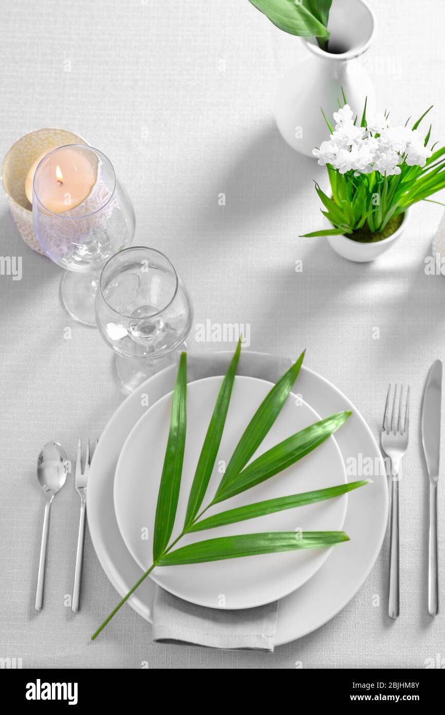 Beautiful table setting with green tropical leaf Stock Photo - Alamy