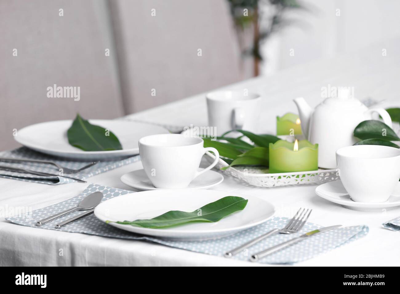Beautiful table setting with green tropical leaves Stock Photo - Alamy