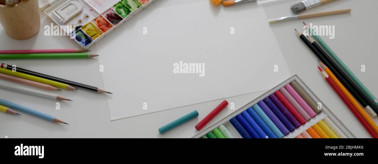 Top view of artist workspace with sketch paper, oil pastels, painting ...